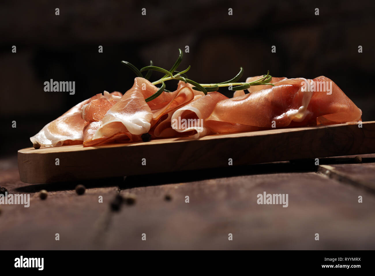 Italian prosciutto crudo or jamon with rosemary. Raw ham on wooden ...