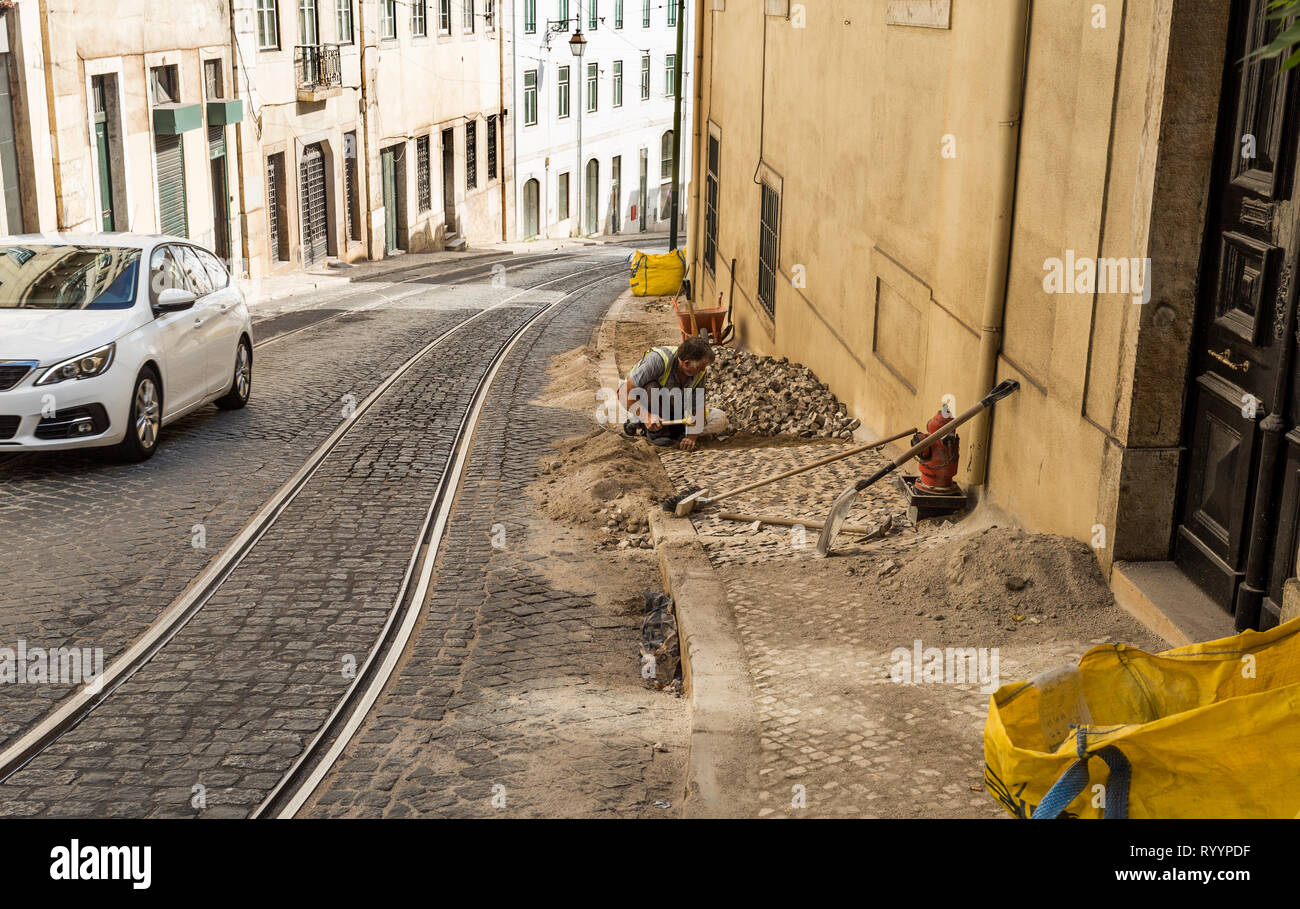 View of a traditional professional paviour person laying cobblestones ...