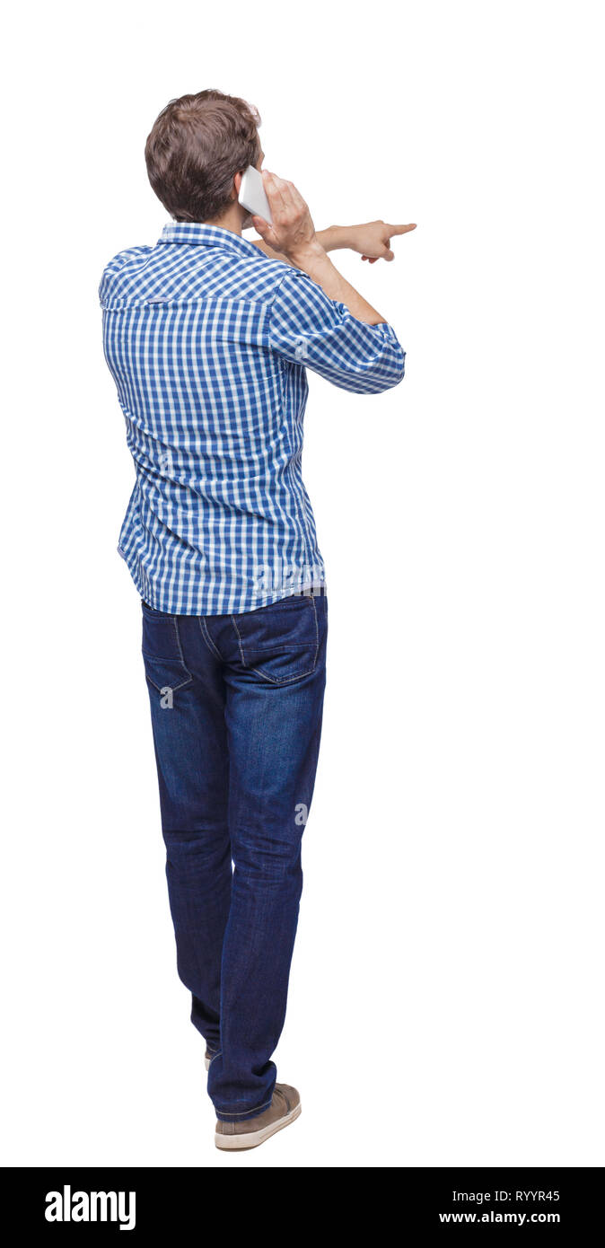 back view of walking man. guy going, pointing and talking on smartphone ...