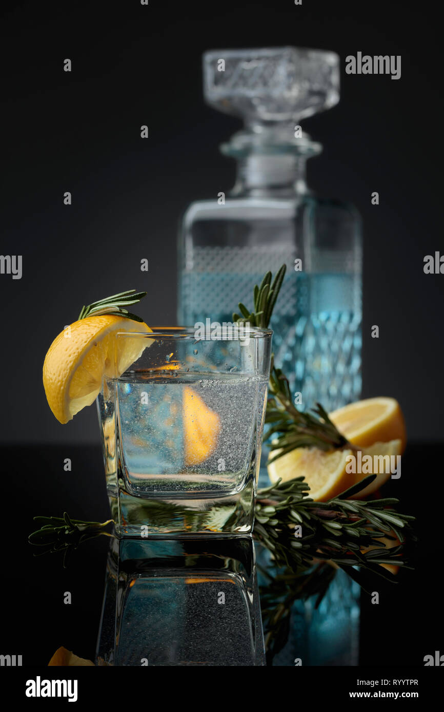 Cocktail gin , tonic with slices of lemon and a sprig of rosemary on a ...