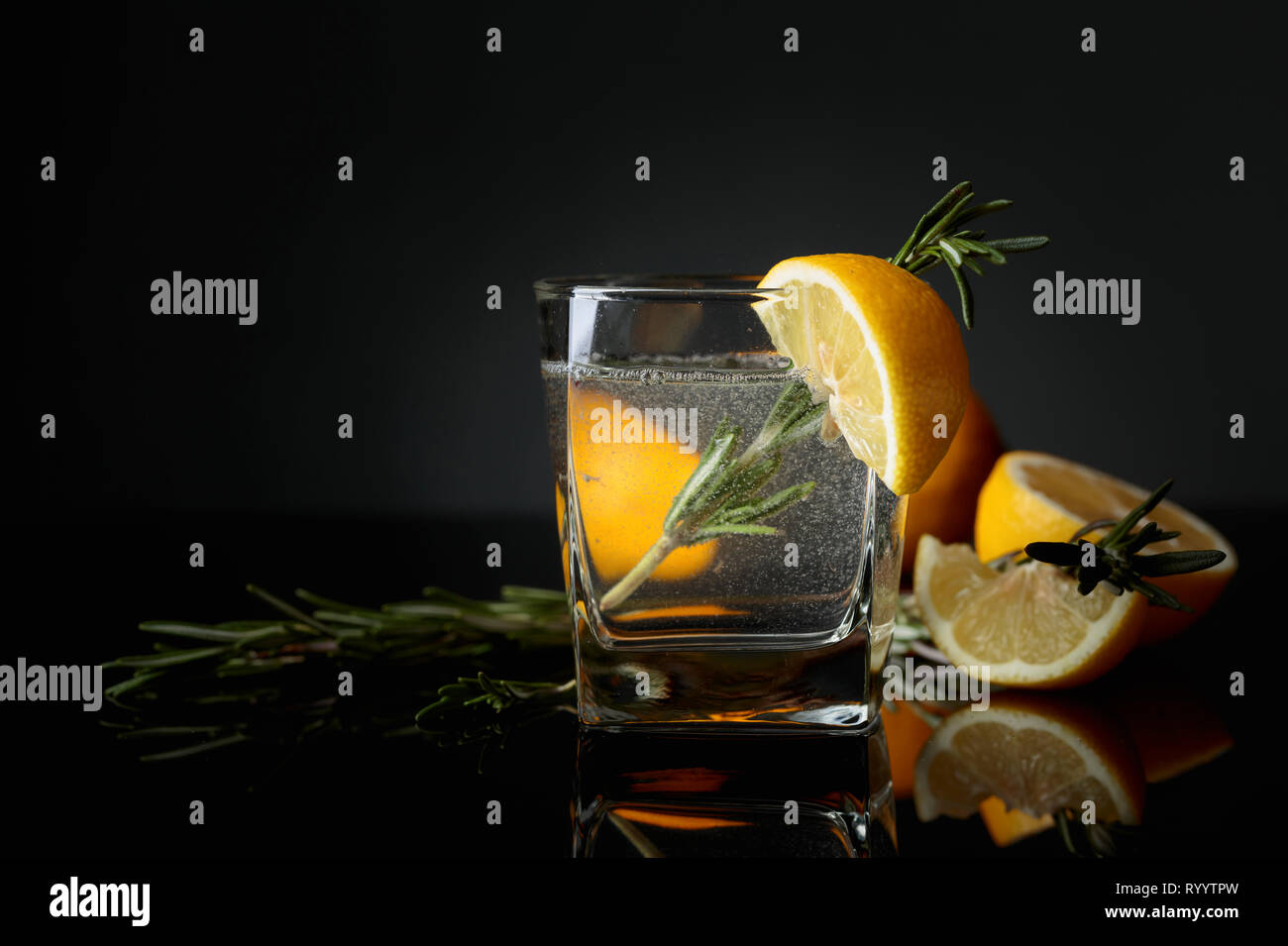 Cocktail gin , tonic with slices of lemon and a sprig of rosemary on a ...