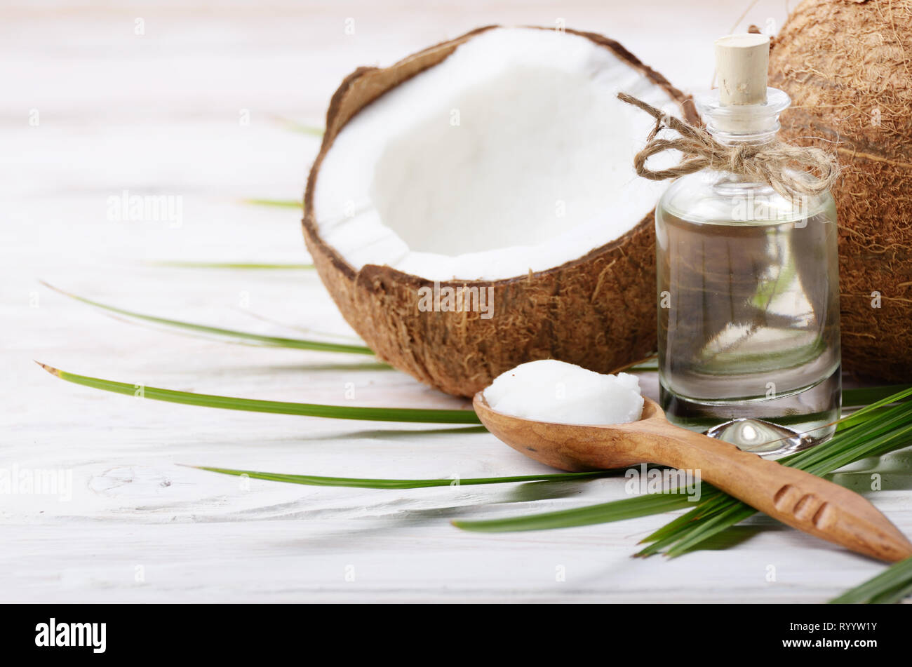 Coconut shell pieces and palm leaves on white wooden table Stock Photo ...
