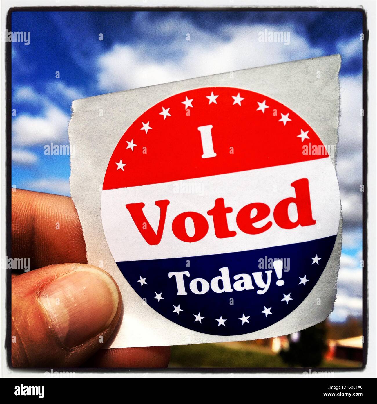 Hand holding an "I voted today"sticker against clouds in the sky Stock ...