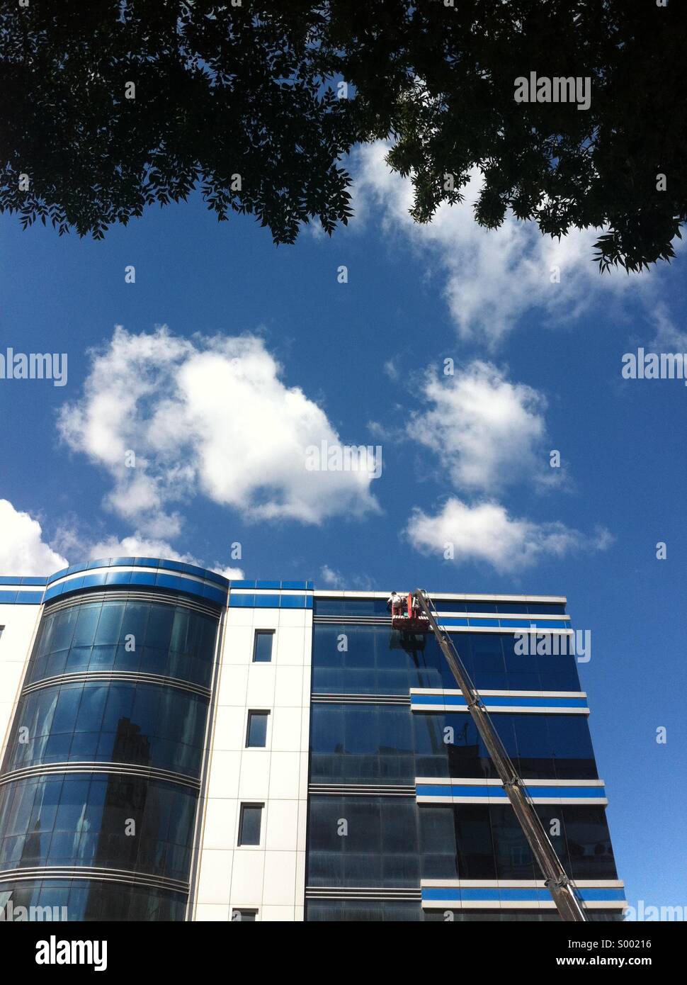 Workers cleaning window under blue sky Stock Photo - Alamy