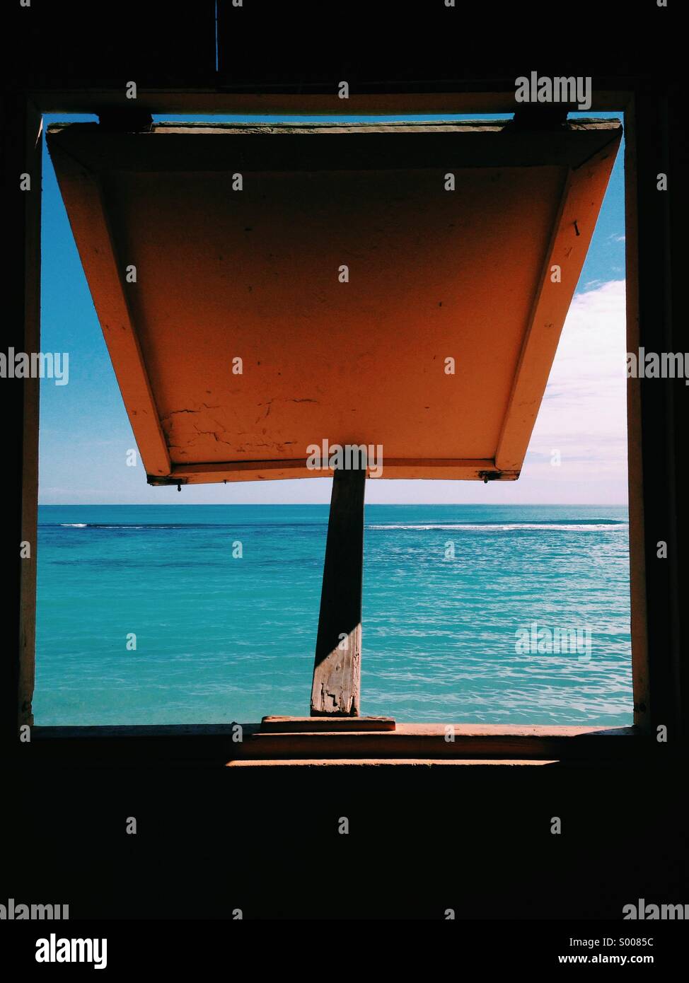 Looking out a window at a Jamaican bar with the ocean in the background ...