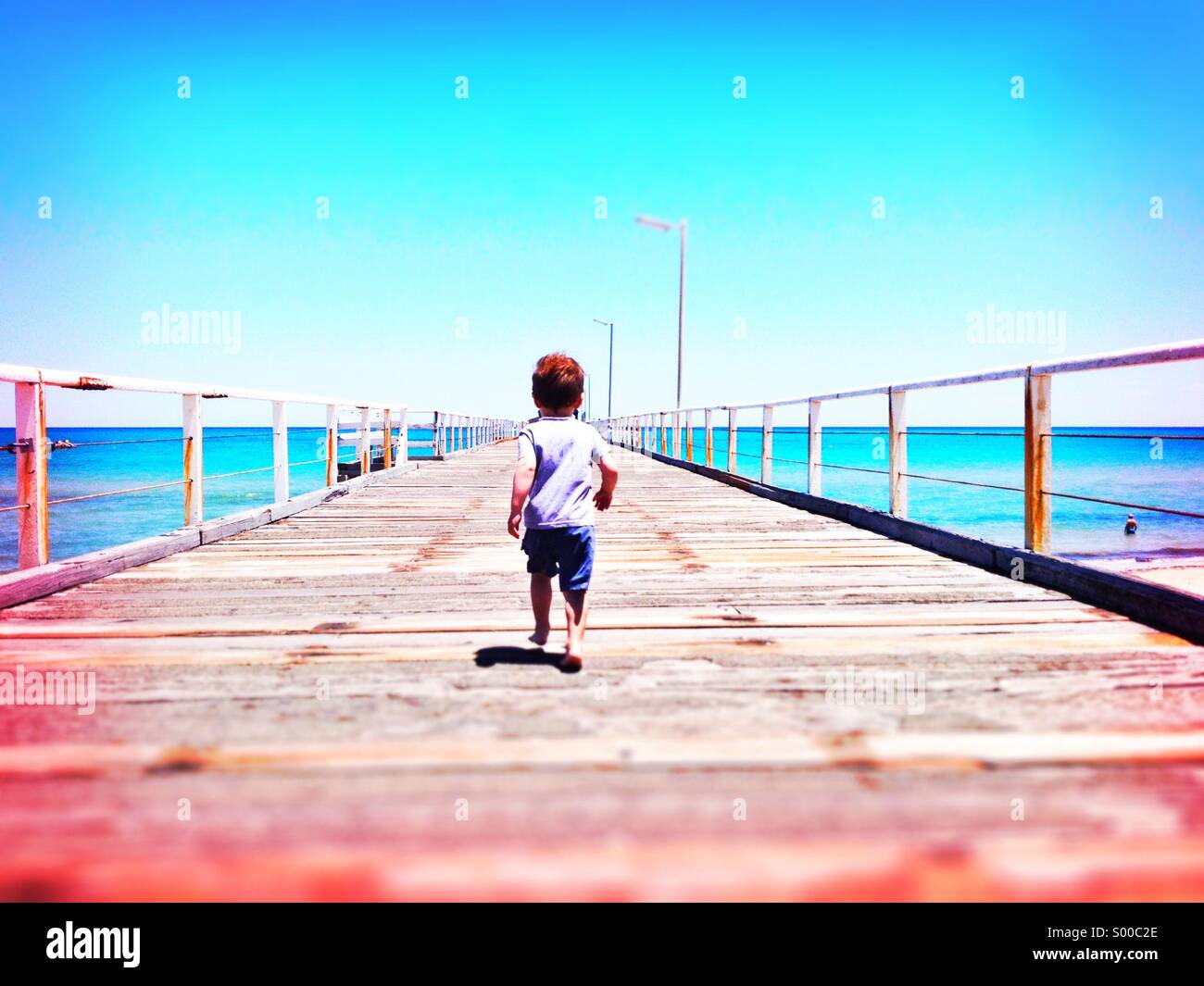 My boy running down a jetty Stock Photo - Alamy