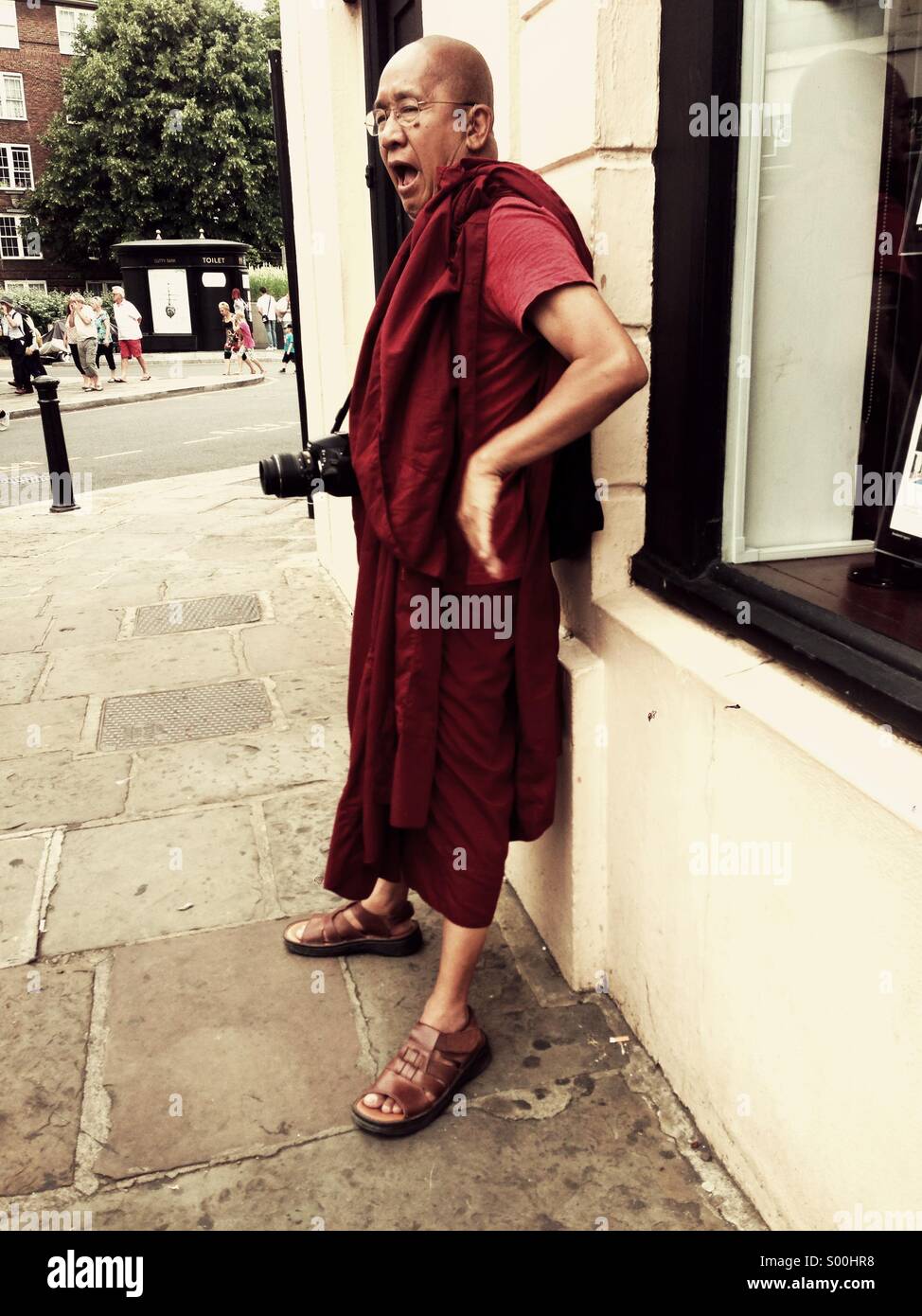 Tired monk photographer yawning Stock Photo - Alamy