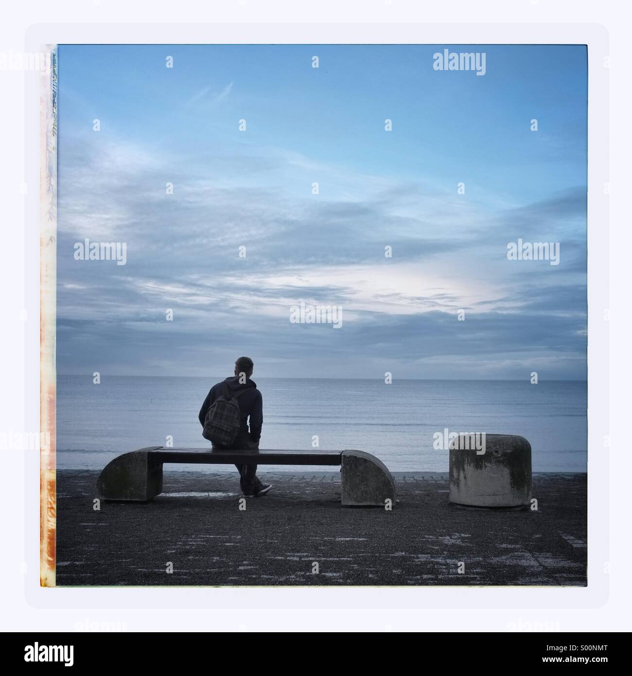 aman sitting on a seaside bench in the evening aberystwyth uk Stock ...