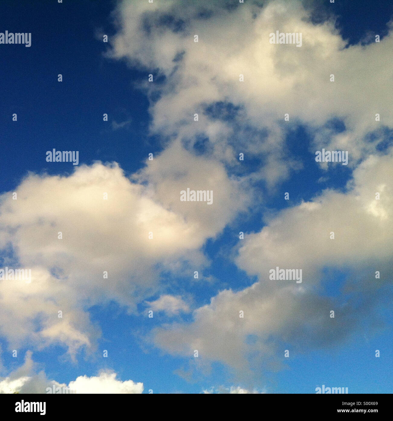 Fluffy clouds in a deep blue sky Stock Photo - Alamy