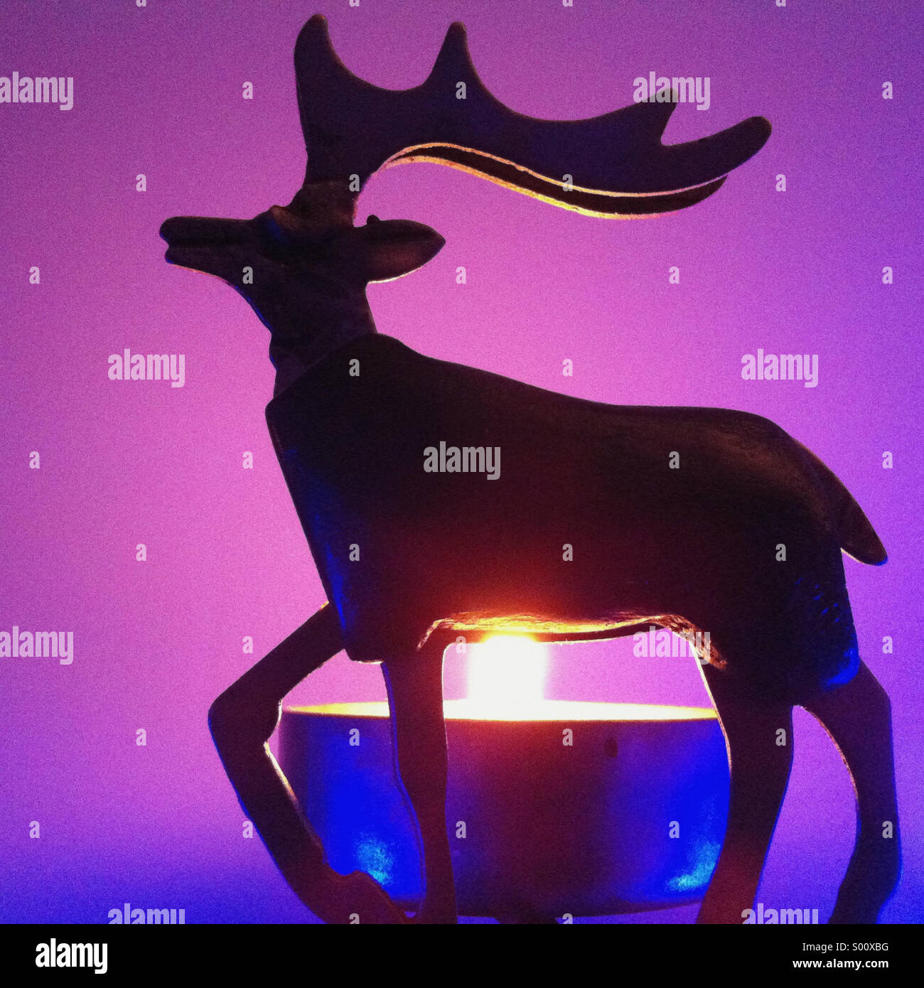 Reindeer candle holder silhouetted against a purple background Stock ...