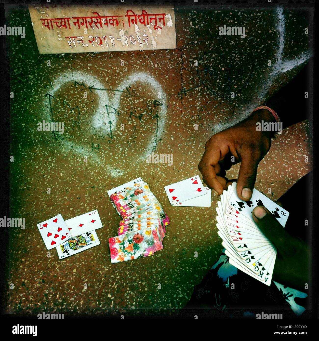 Man is playing card game on bench Stock Photo - Alamy