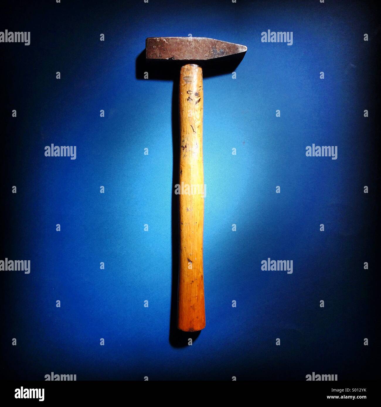 Hammer on blue background Stock Photo - Alamy