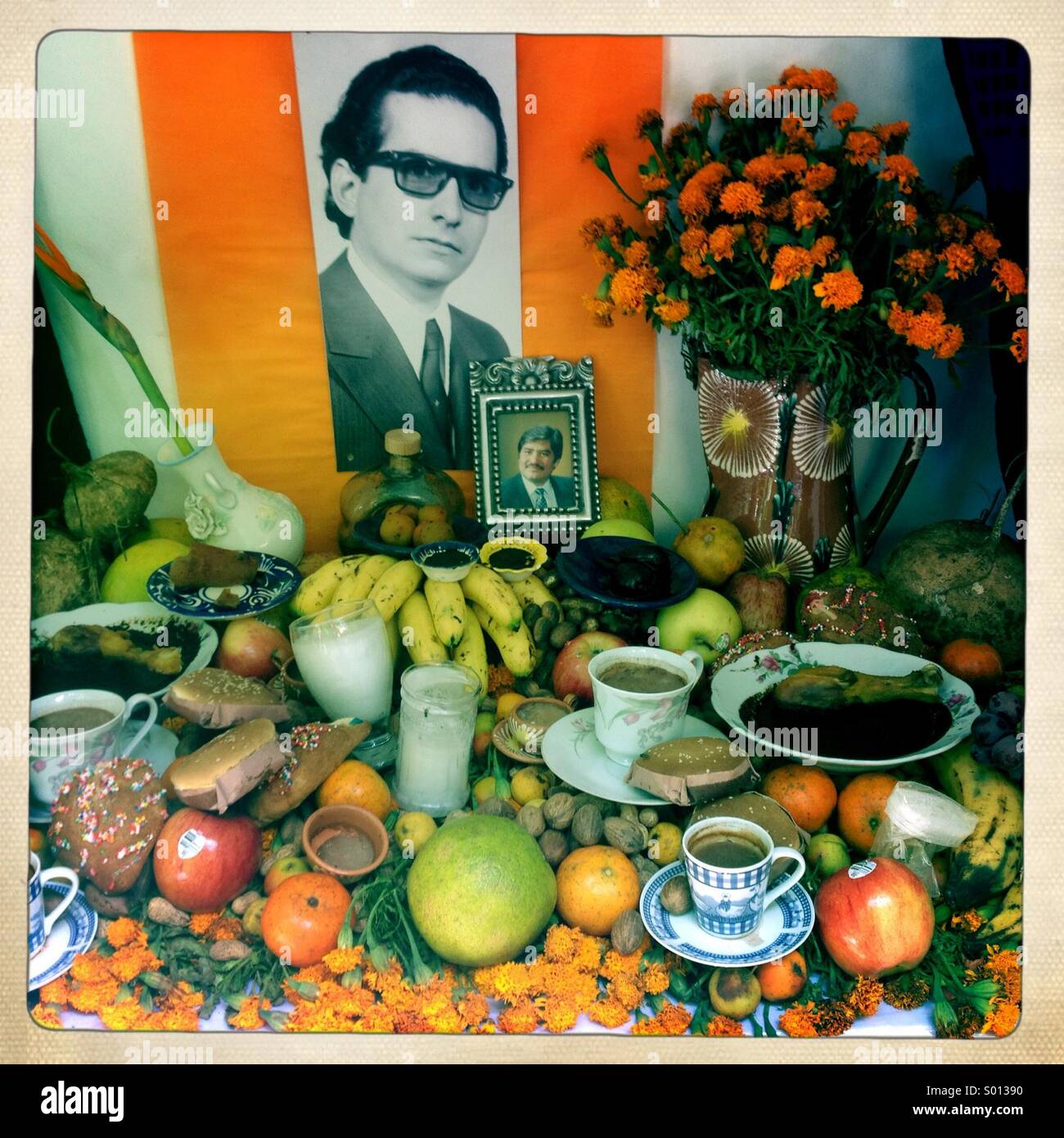 Fruits and food decorate an altar with portraits of deceased people ...