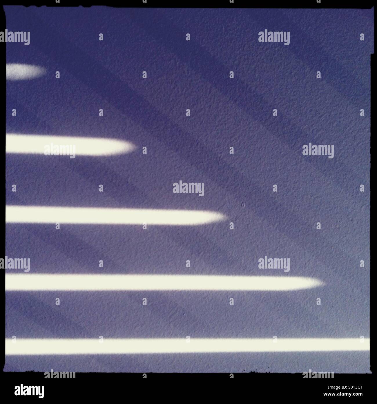 Horizontal strips of light and diagonal strips of shadow on the wall ...