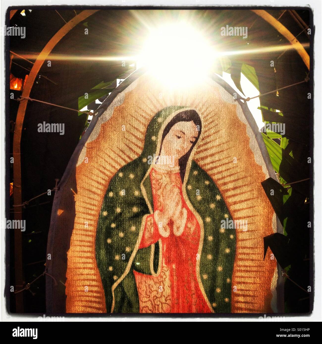 A ray of sunlight crosses an image of the Virgin Mary during the ...