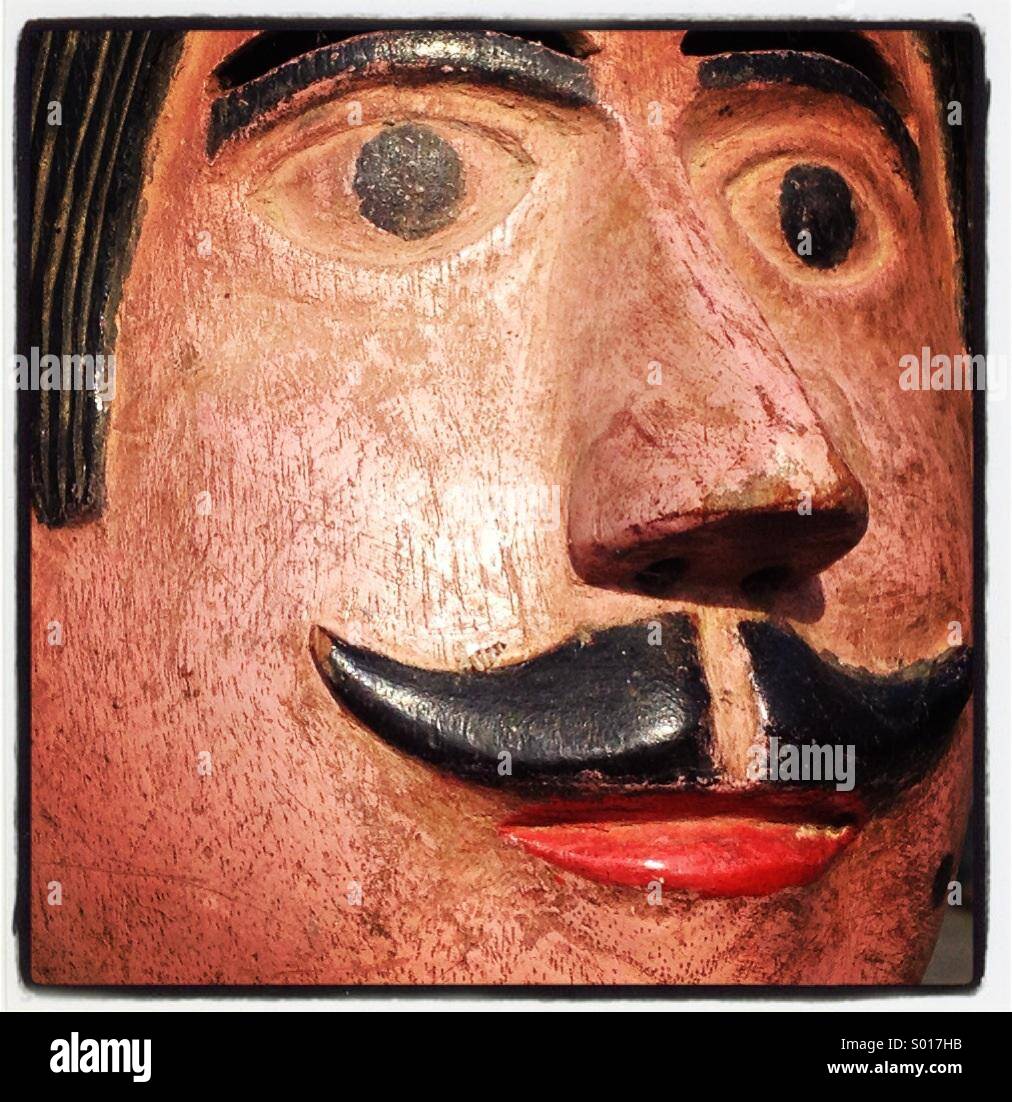 A dancer wears a wooden mask of a man with a moustache during the ...