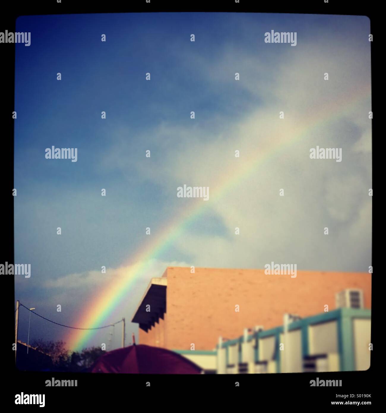 Rainbow over a building Stock Photo - Alamy