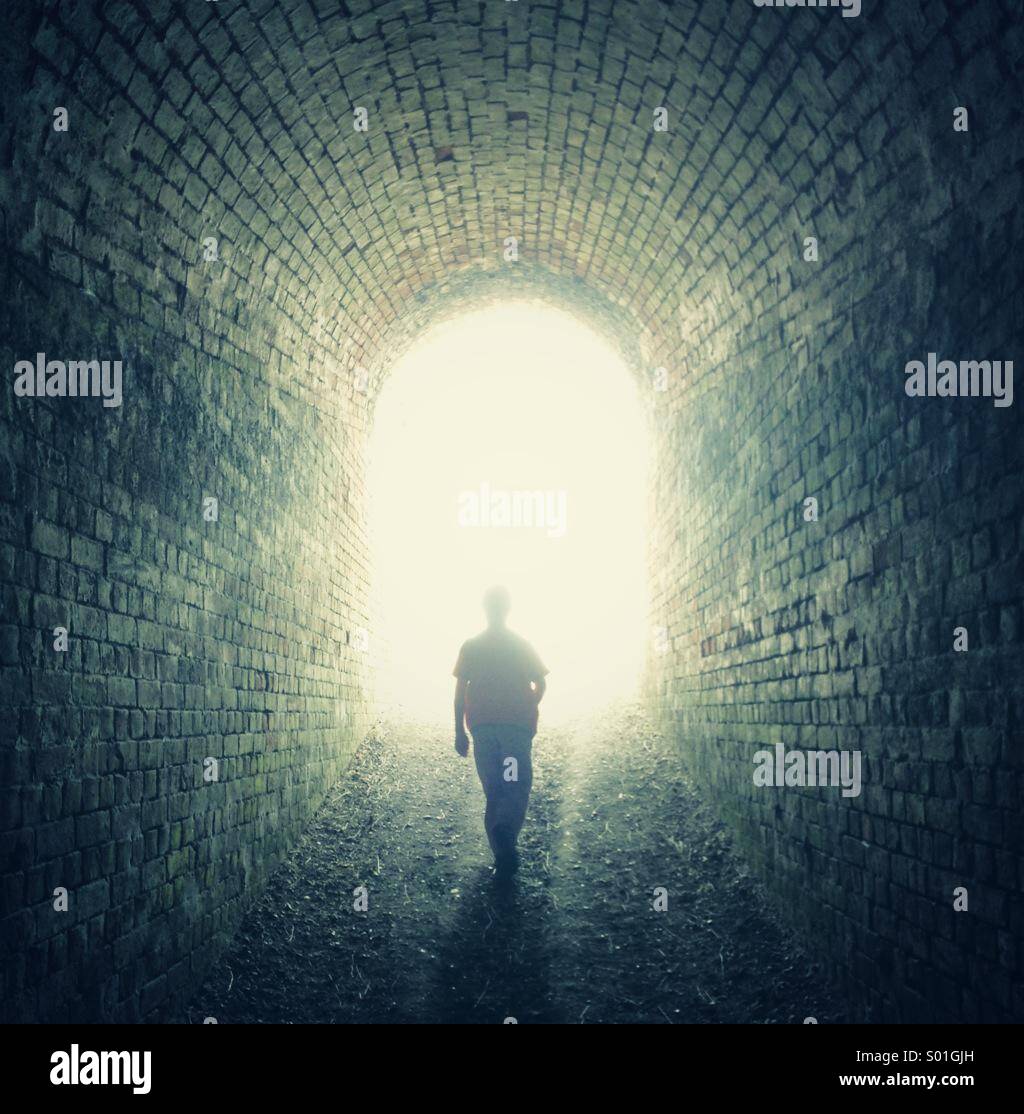 Boy walking through tunnel Stock Photo - Alamy