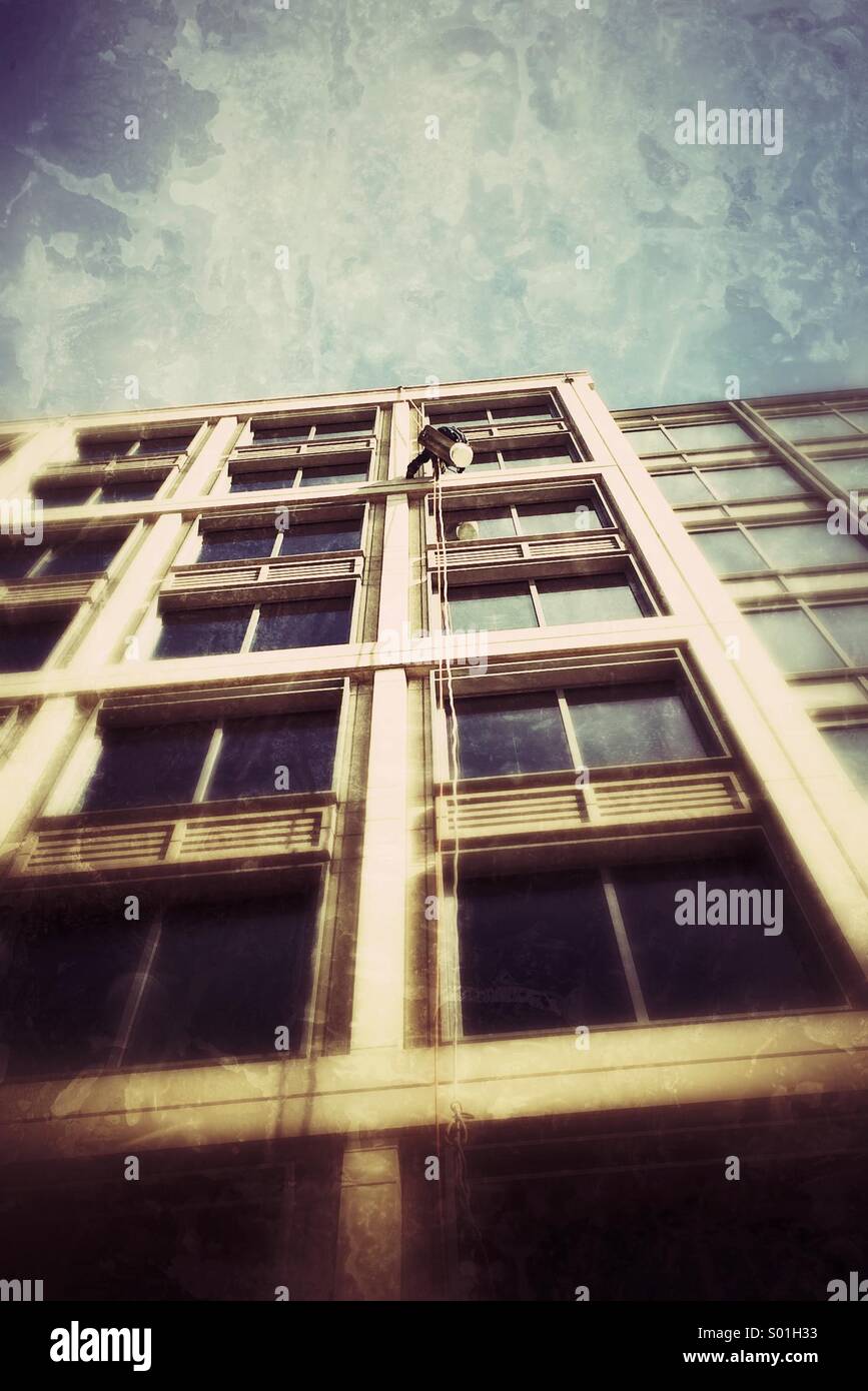 A window washer cleans windows above the street Stock Photo - Alamy