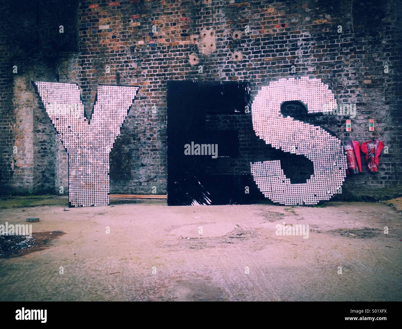 Large YES in mirrored letters against a brick background Stock Photo ...