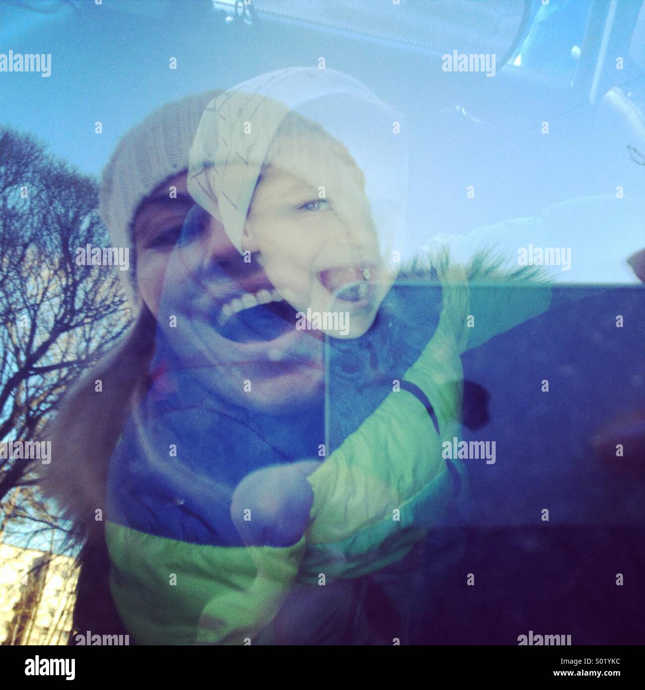 Young woman and child portraits reflection having fun making self ...