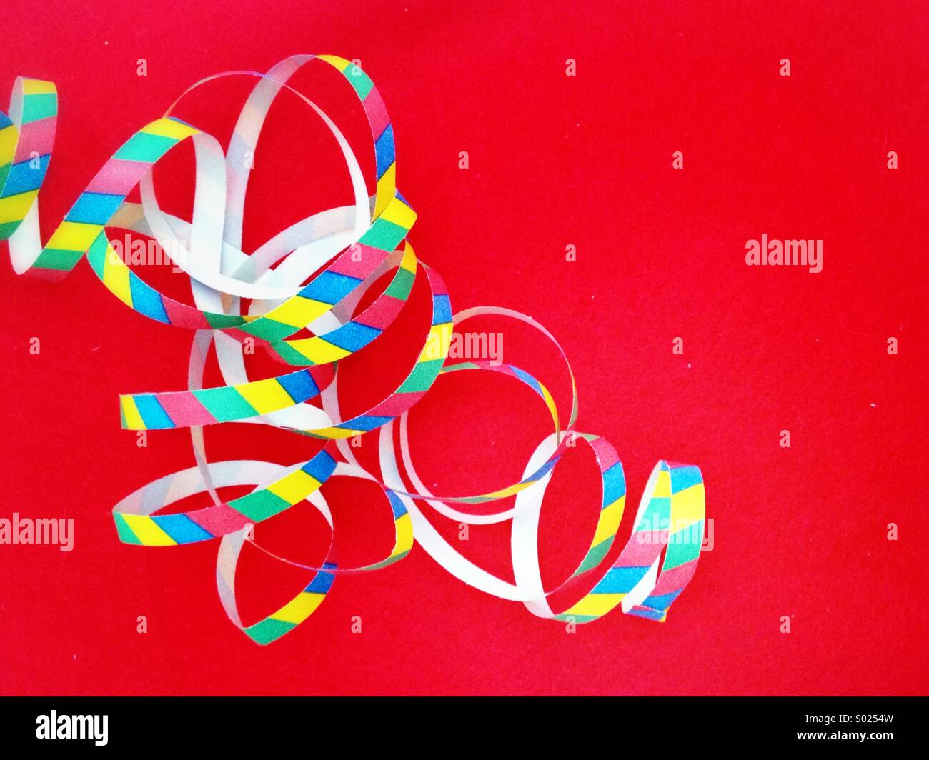 Paper streamers on red background Stock Photo - Alamy