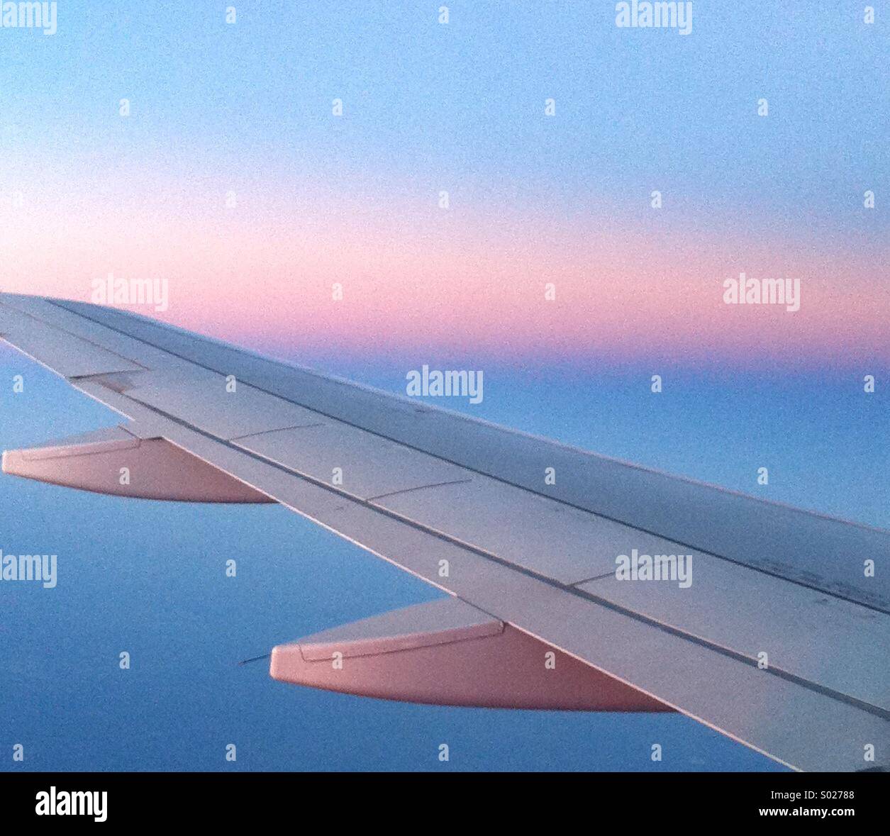 Sunset from the airplane window looking over the wing Stock Photo - Alamy