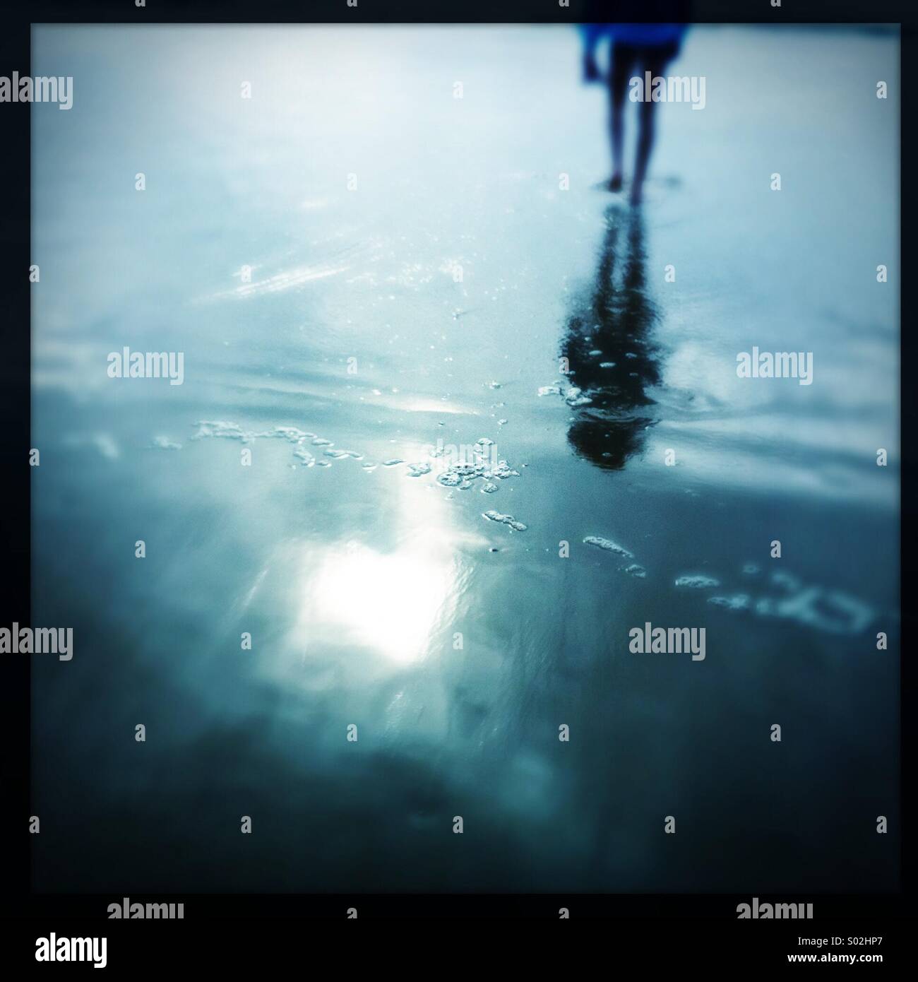 reflection of person walking on wet sand Stock Photo - Alamy