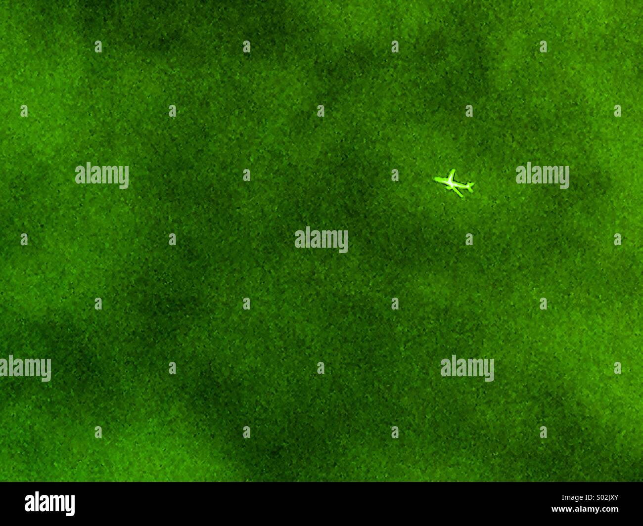 Small outline of plane on green background Stock Photo - Alamy