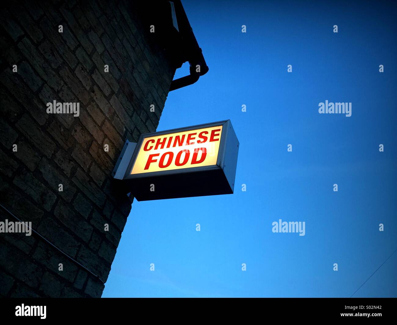 A Chinese food sign on a wall lit up at night Stock Photo - Alamy