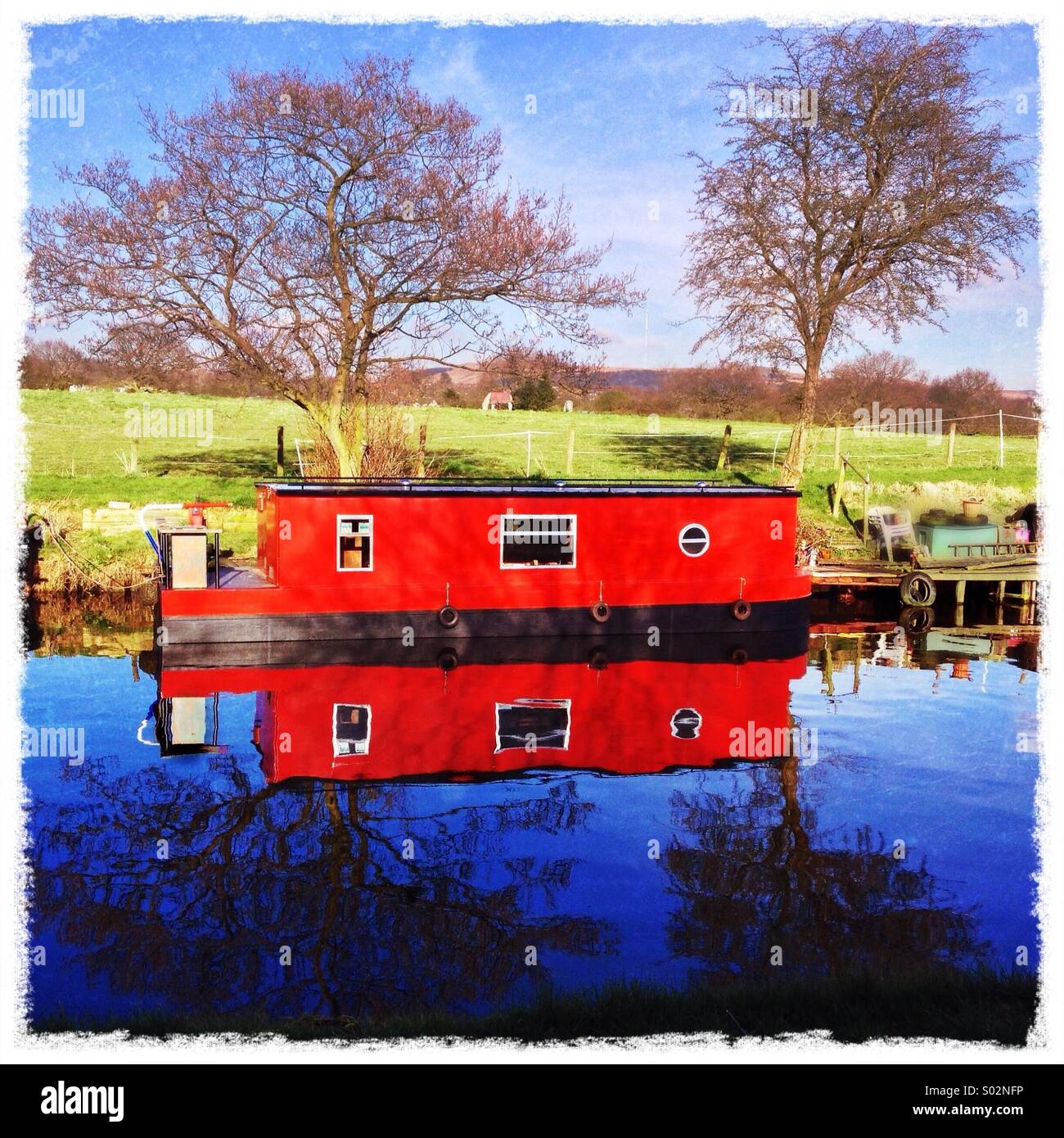 Symmetrical reflection of red barge in canal Stock Photo - Alamy