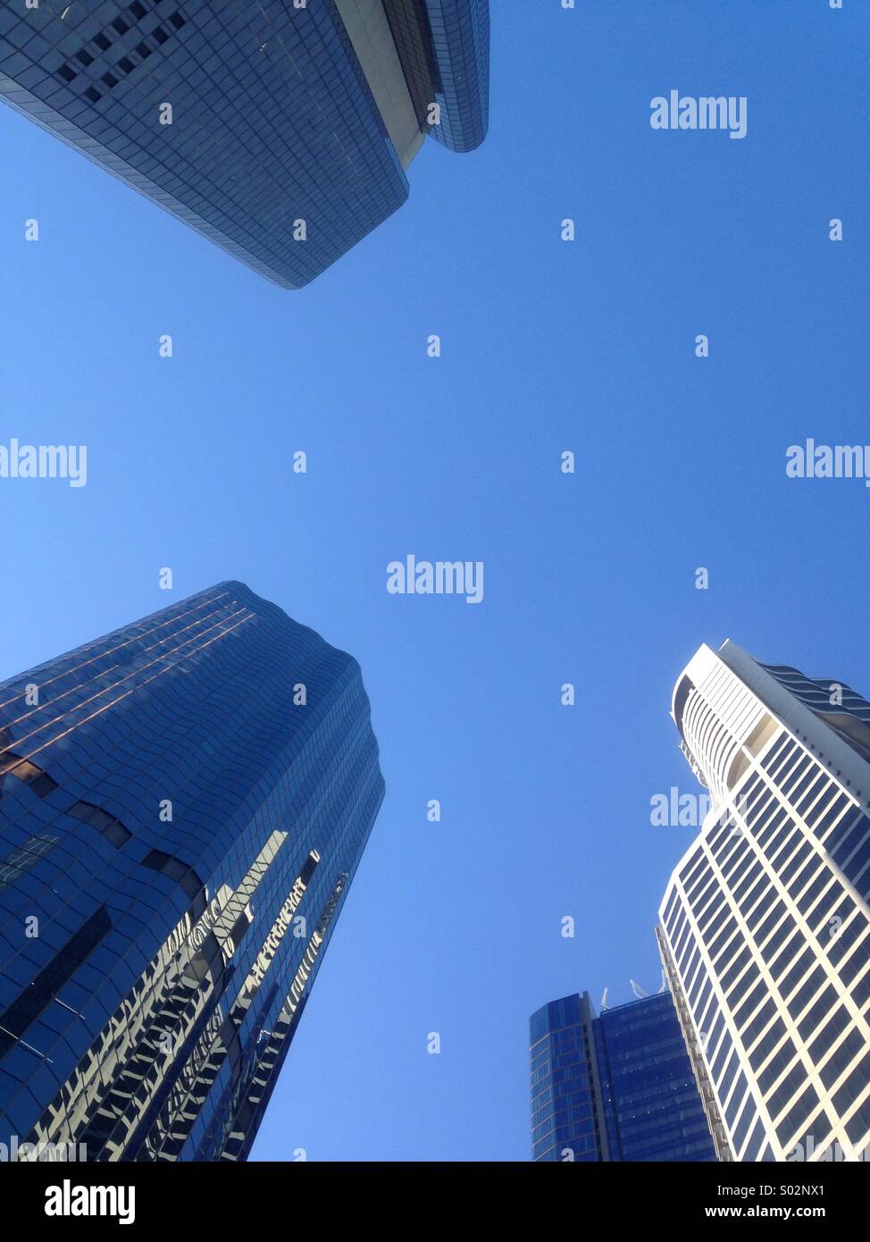 Look up to see high rise buildings and blue sky Stock Photo - Alamy