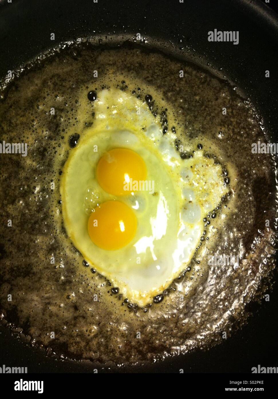Egg double yoke in frying pan Stock Photo - Alamy