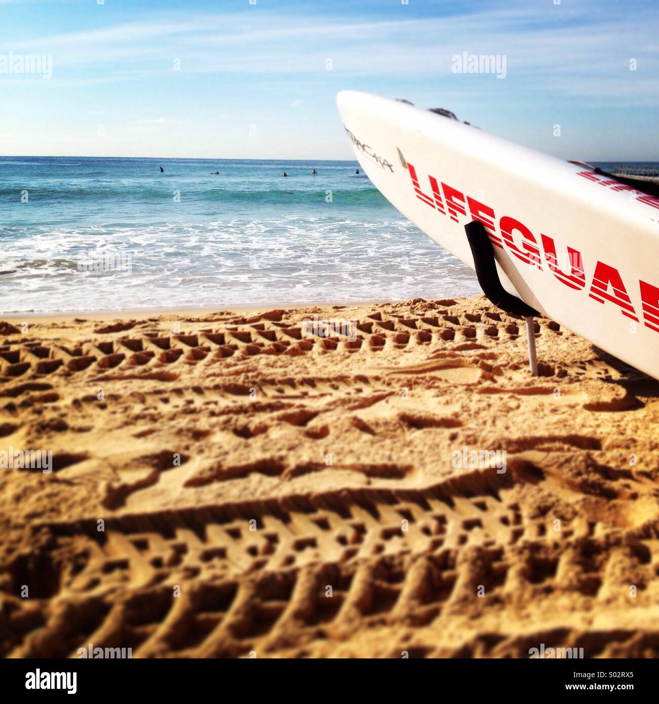 Lifeguard surfboard on sandy beach by the sea Stock Photo - Alamy