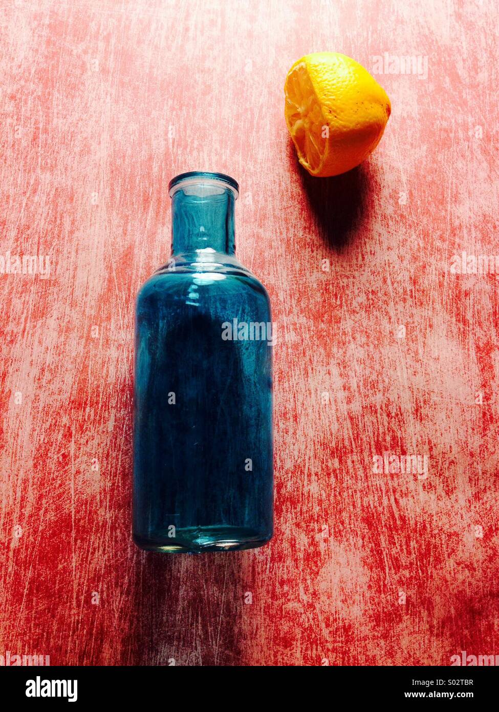 Blue bottle and half "used" lemon Stock Photo - Alamy