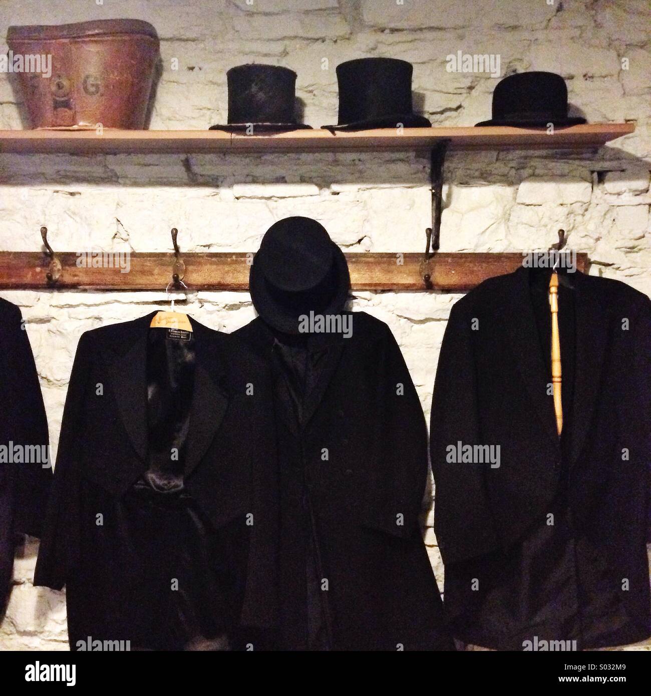 Suits and top hats from below stairs Stock Photo - Alamy