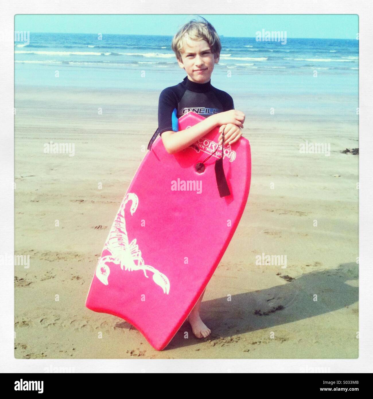 A young boy with a bodyboard on the beach Stock Photo - Alamy