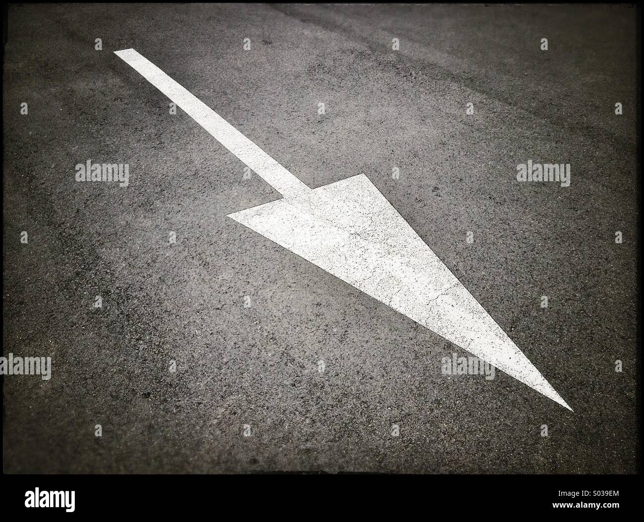 Painted white arrow sign on asphalt Stock Photo - Alamy