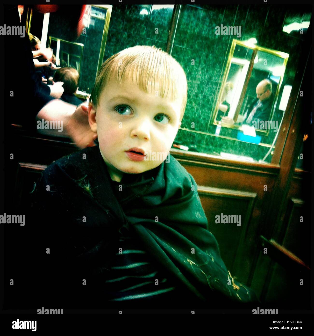 A young boy has his first hair cut at the barbers Stock Photo - Alamy