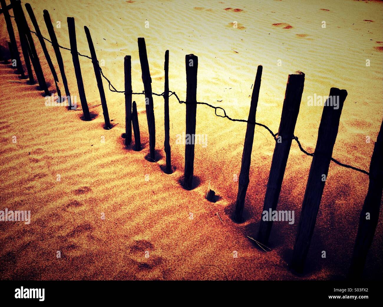 Broken fence in sand Stock Photo - Alamy