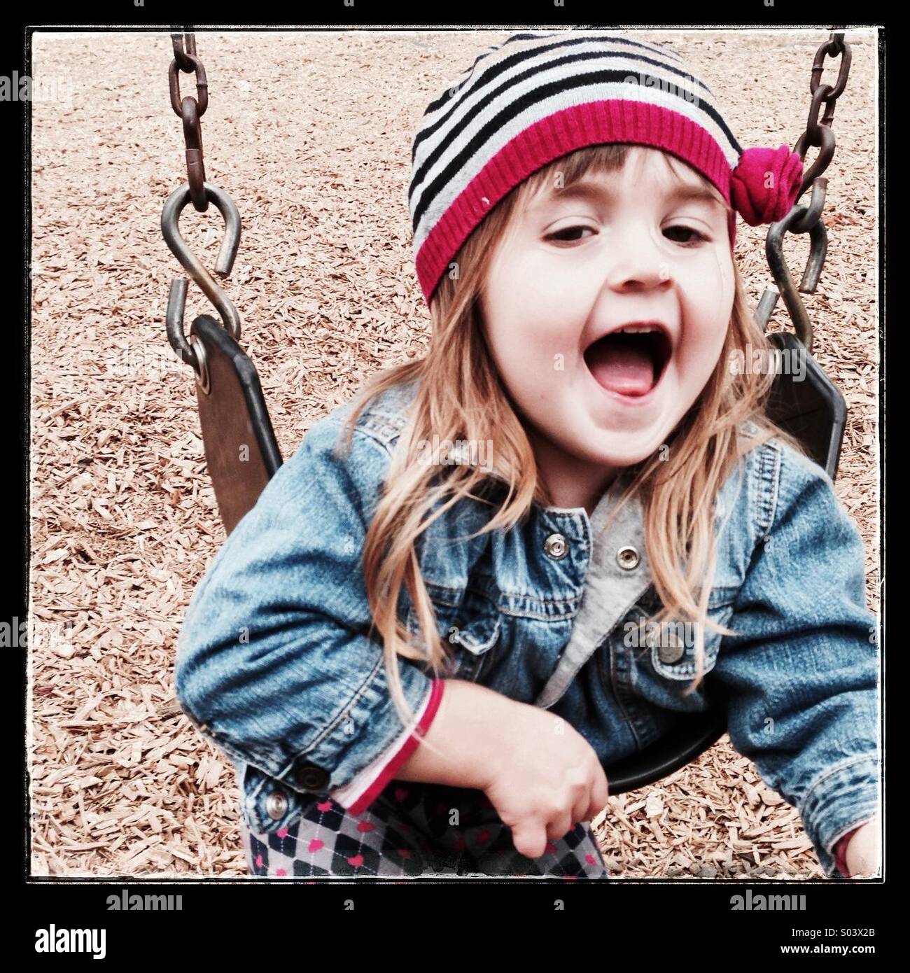 Toddler Caucasian girl having fun on a swing Stock Photo - Alamy