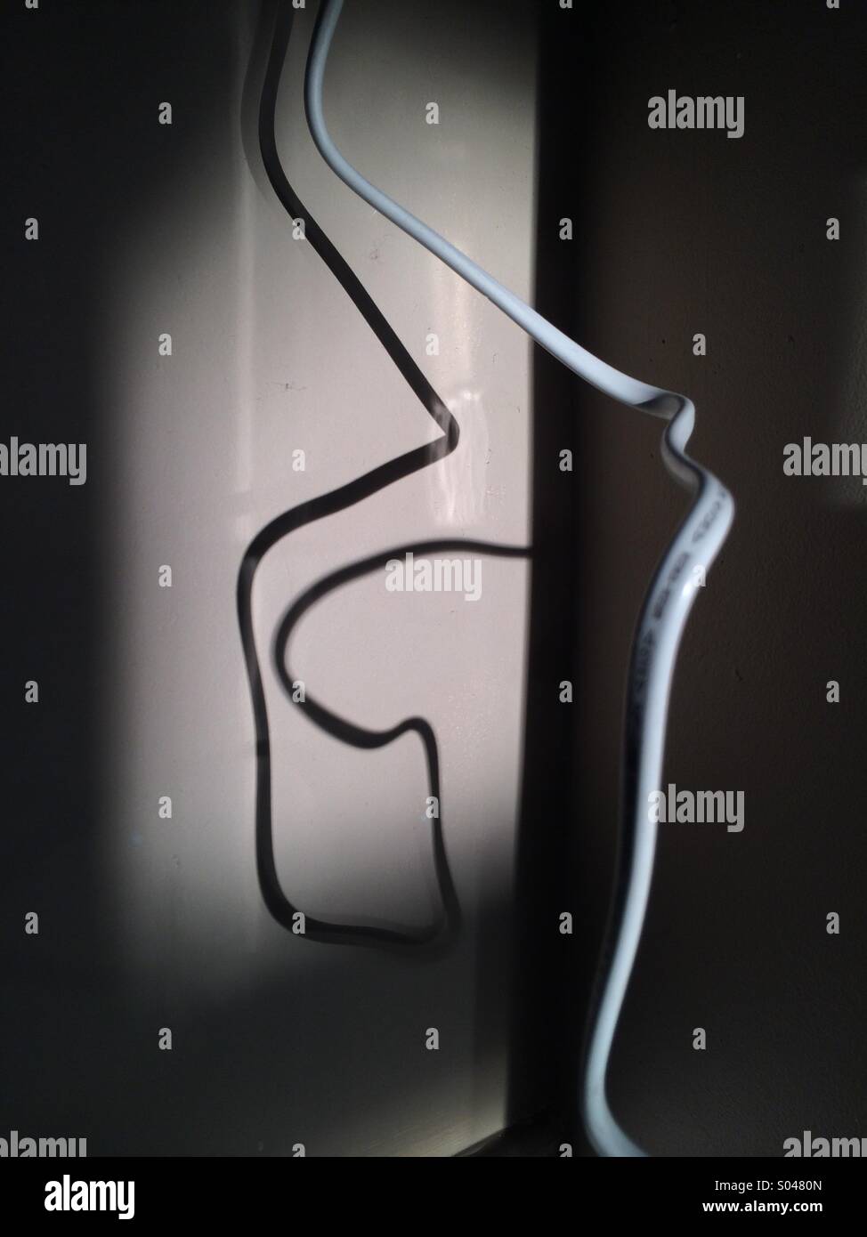 Electrical wire casts a shadow on a wall Stock Photo - Alamy