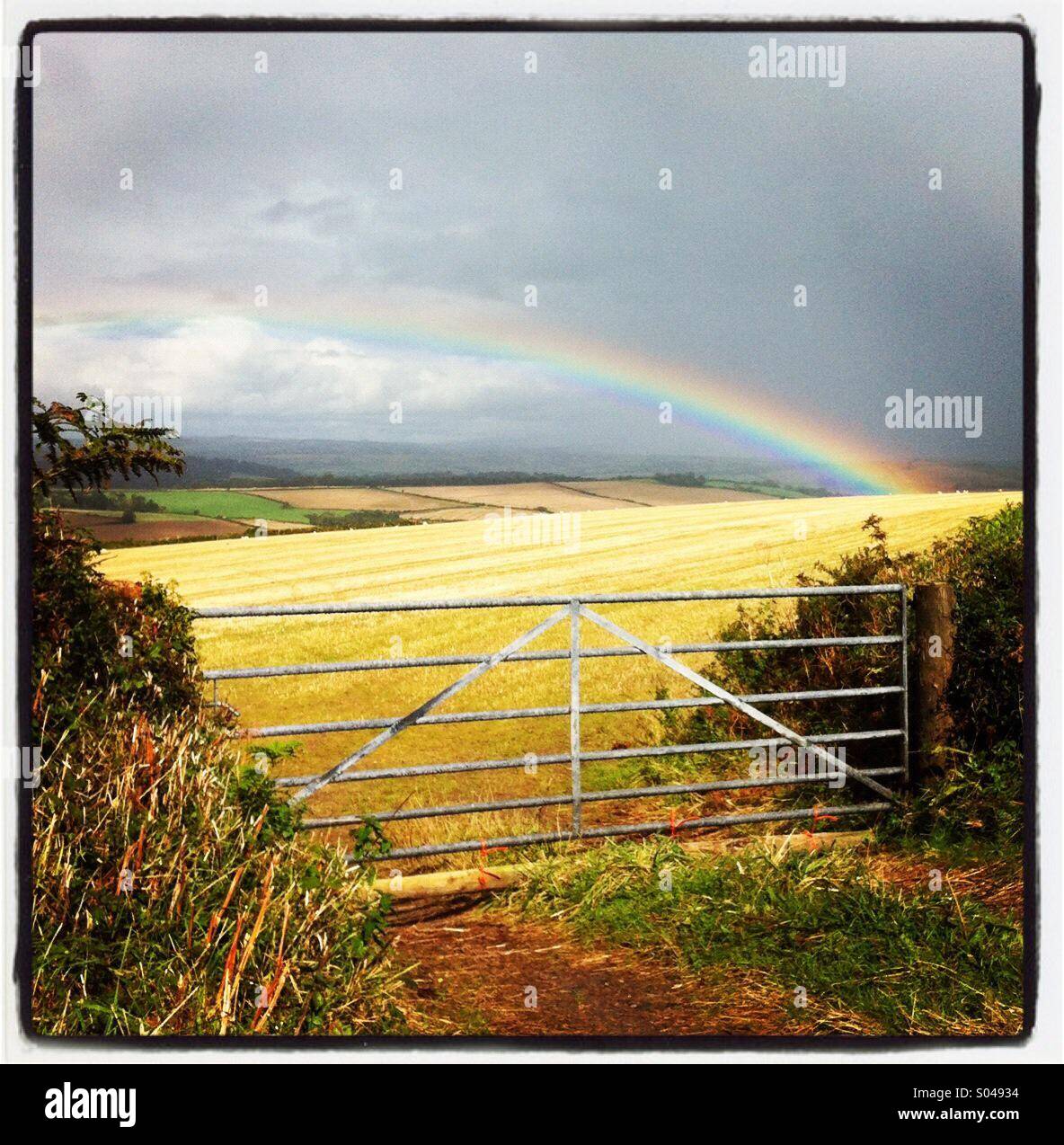 Rainbow over country gate Stock Photo - Alamy