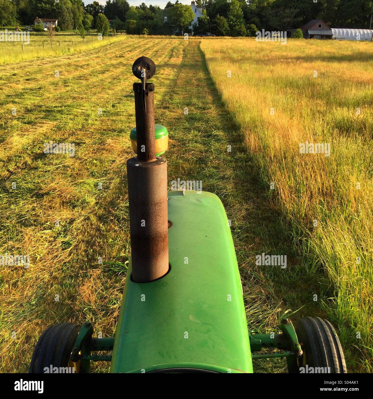 Tractor in hay field Stock Photo - Alamy