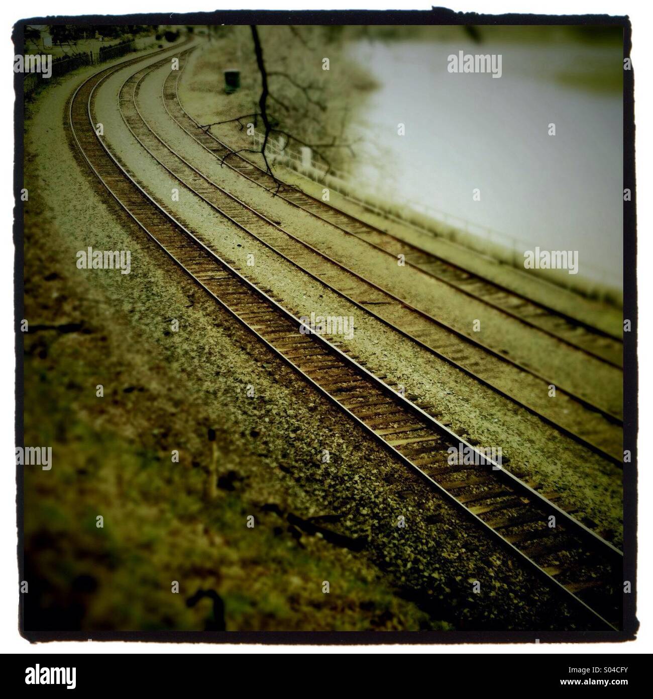 Empty train tracks along waterway Stock Photo - Alamy