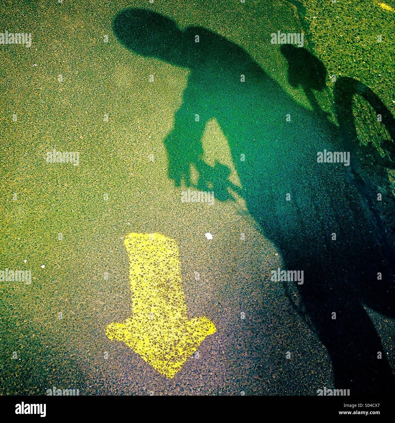 shadow of bike with rider and yellow arrow Stock Photo - Alamy