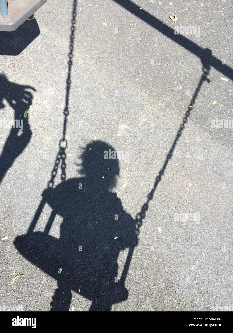Shadow of a young child on a swing Stock Photo - Alamy