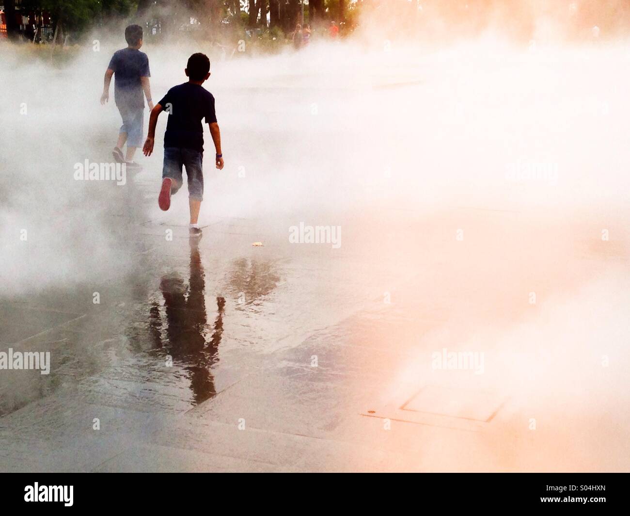 Two boys running through the mist Stock Photo - Alamy