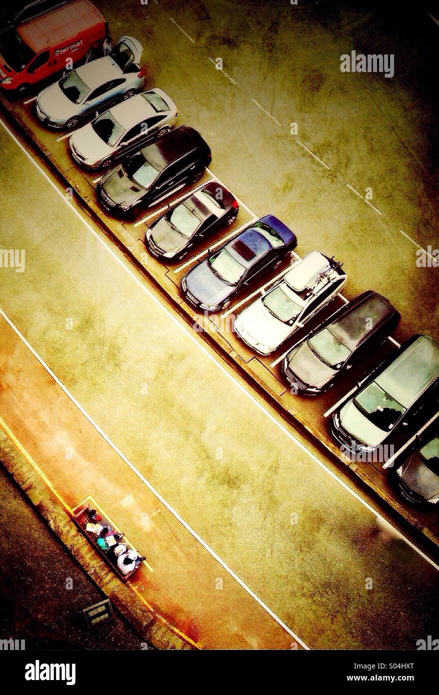 Family eating on bench opposite car park Stock Photo - Alamy