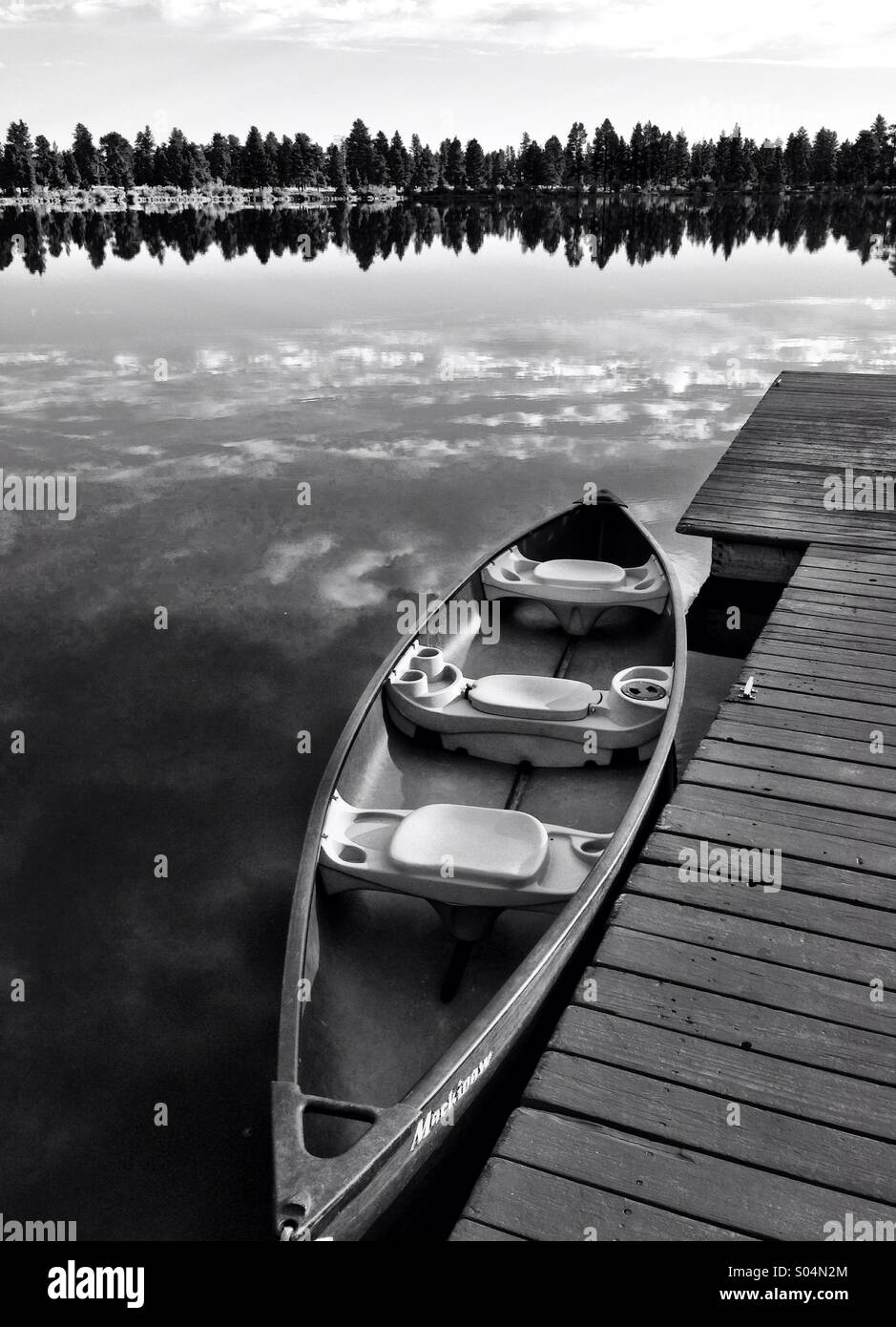 Canoe on glassy lake in forest, b/w Stock Photo - Alamy